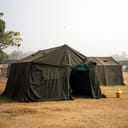 encampment (【Noun】a group of huts, tents, etc. set up as a temporary ...